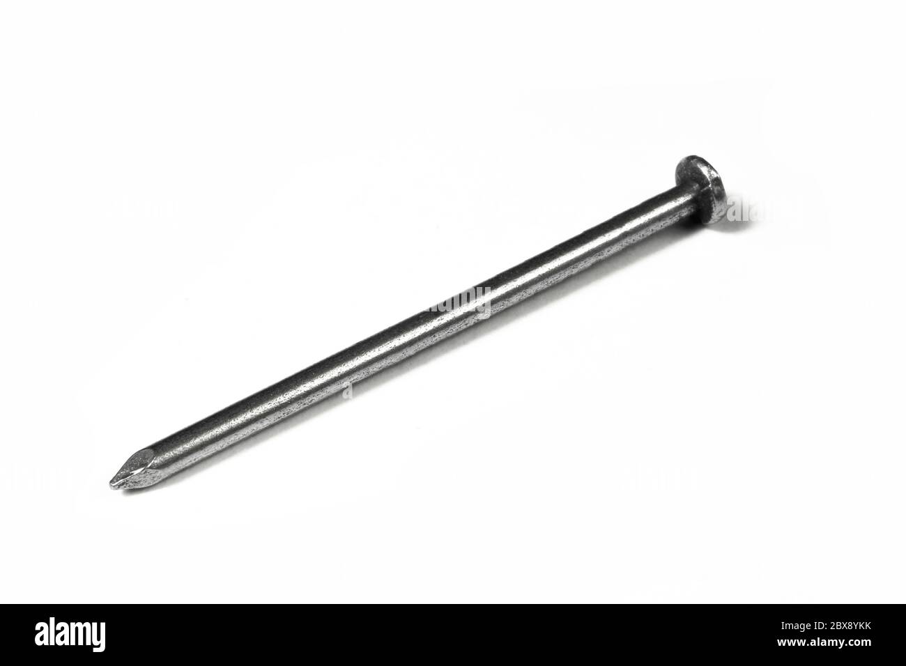 A single metallic nail isolated on white background Stock Photo - Alamy