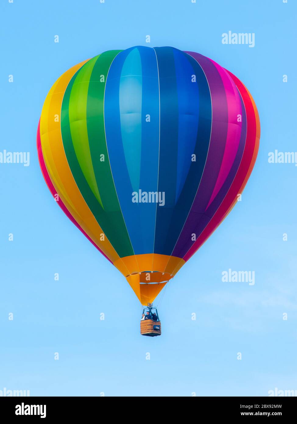 Hot air balloon in rainbow spectrum colors on blue sky background Stock ...