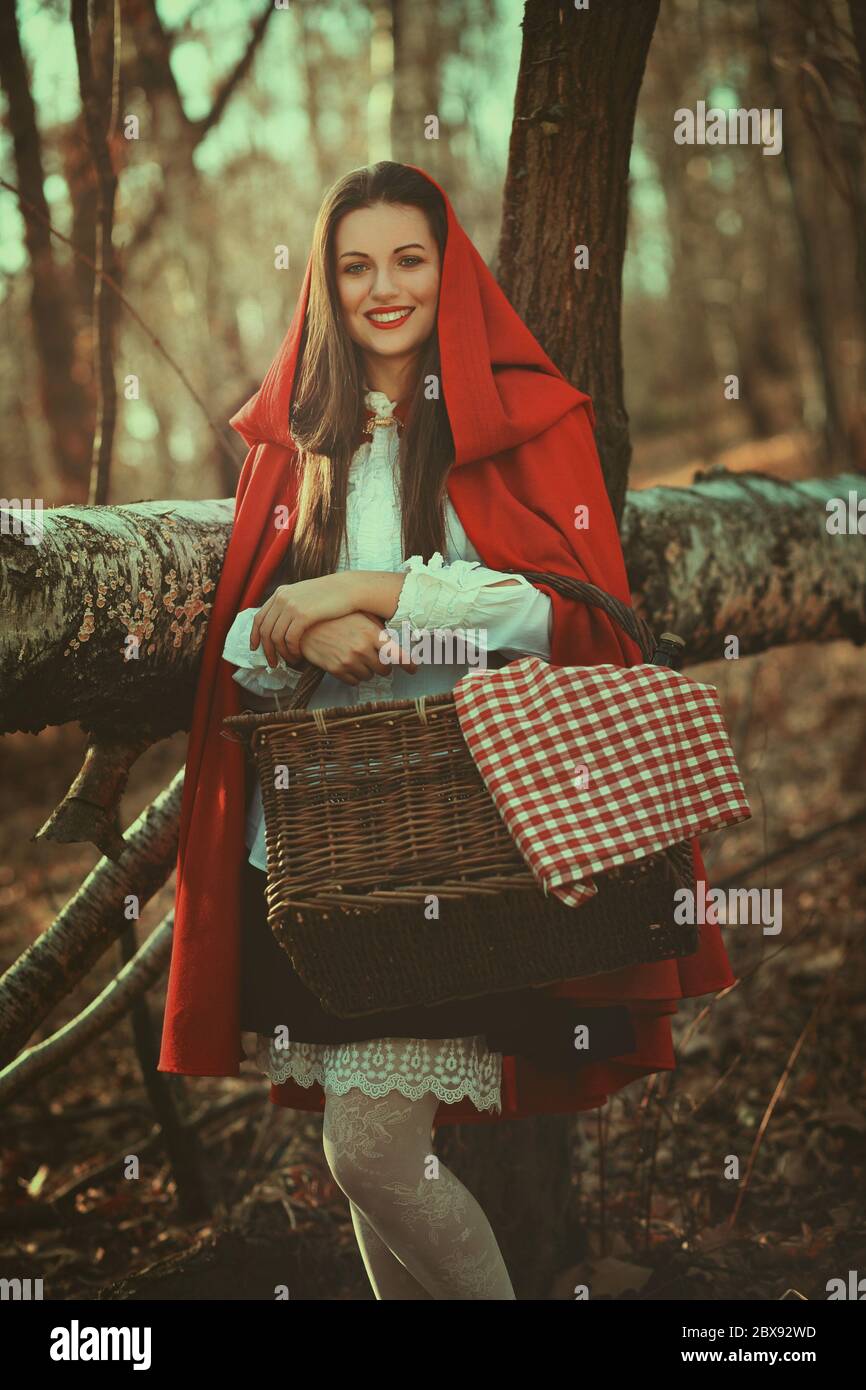 Beautiful and smiling little red riding hood posing in the forest Stock ...