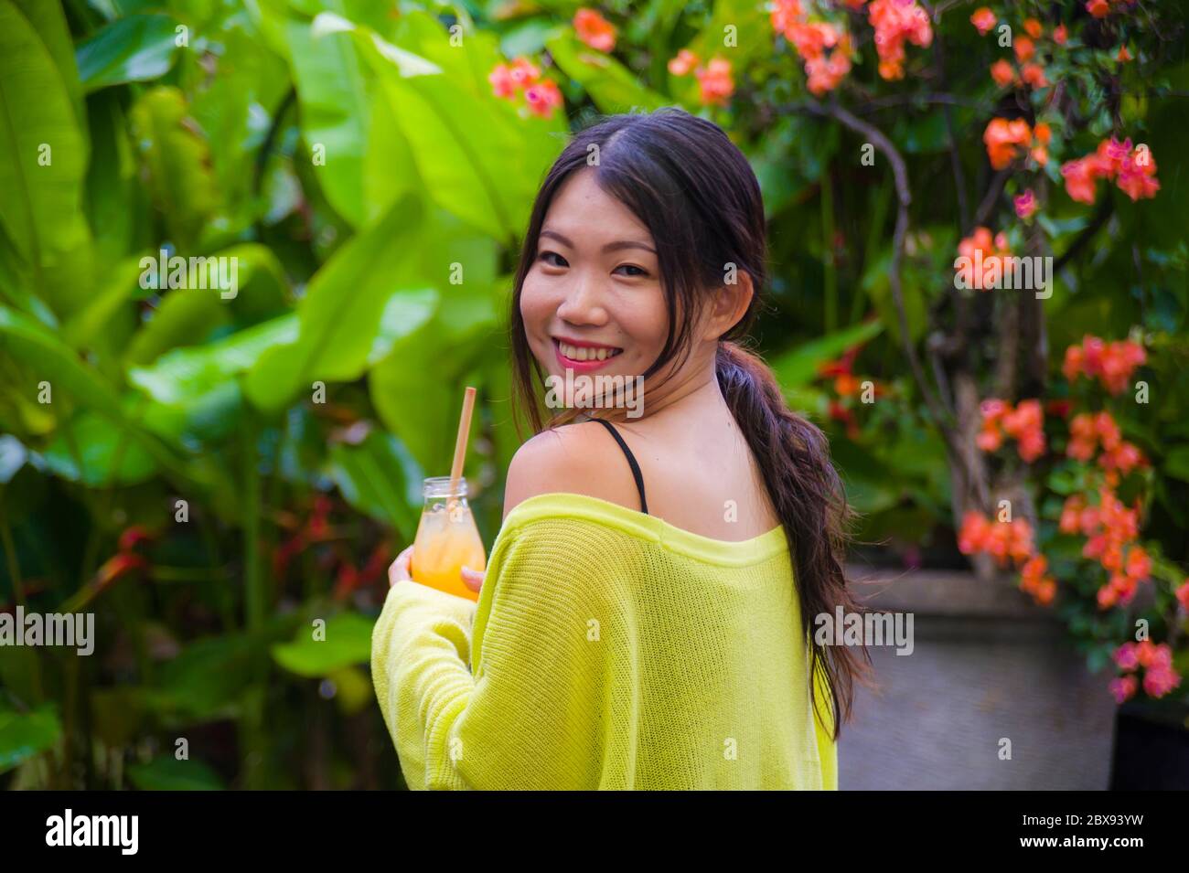 young attractive and happy Asian Chinese girl having fun in garden ...