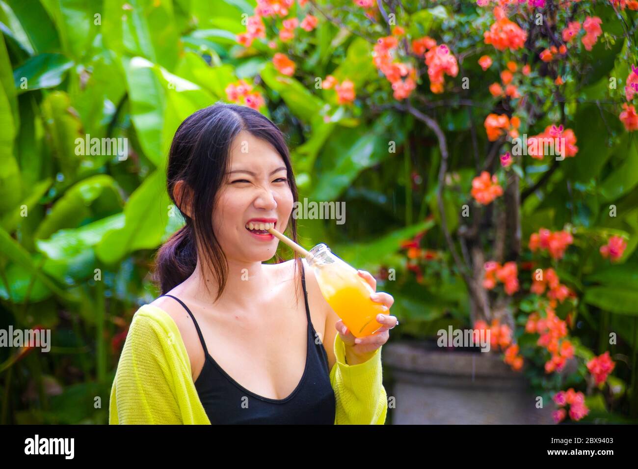young attractive and happy Asian Chinese girl having fun in garden ...