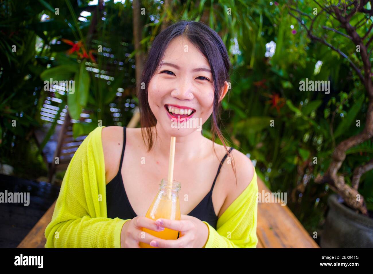 young attractive and happy Asian Chinese girl having fun in garden ...