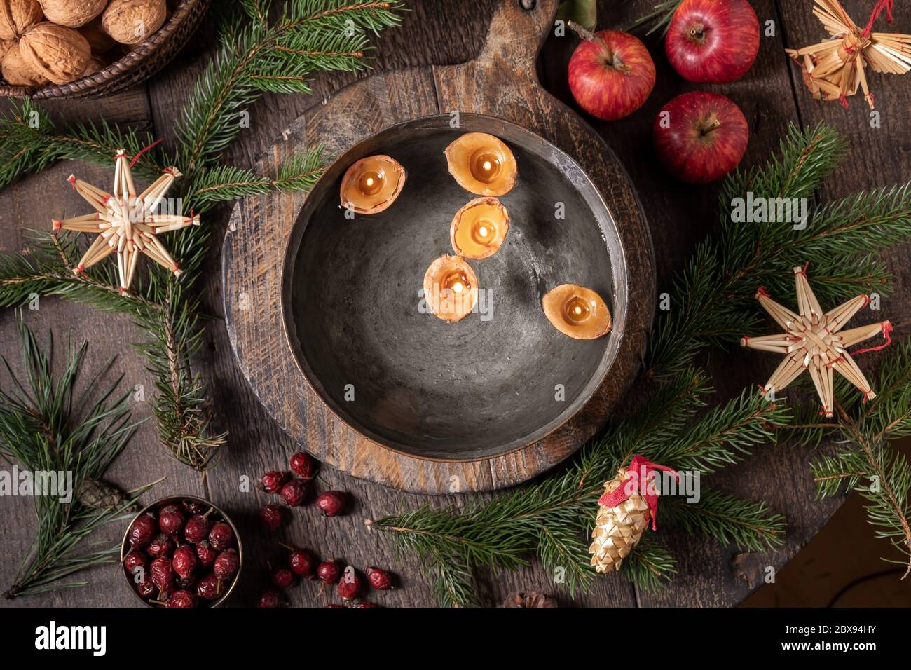 Candles made from nut shells floating in a bowl of water, top view ...