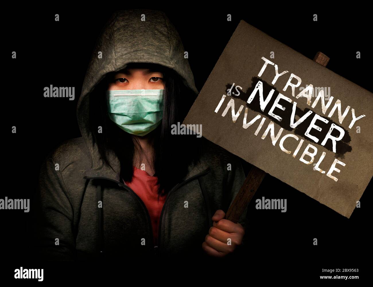 young angry Asian activist girl holding protest banner against China ...