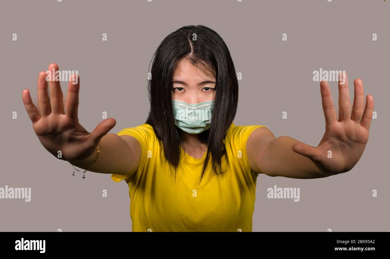 young beautiful pacifist Asian woman in face mask angry and outraged ...