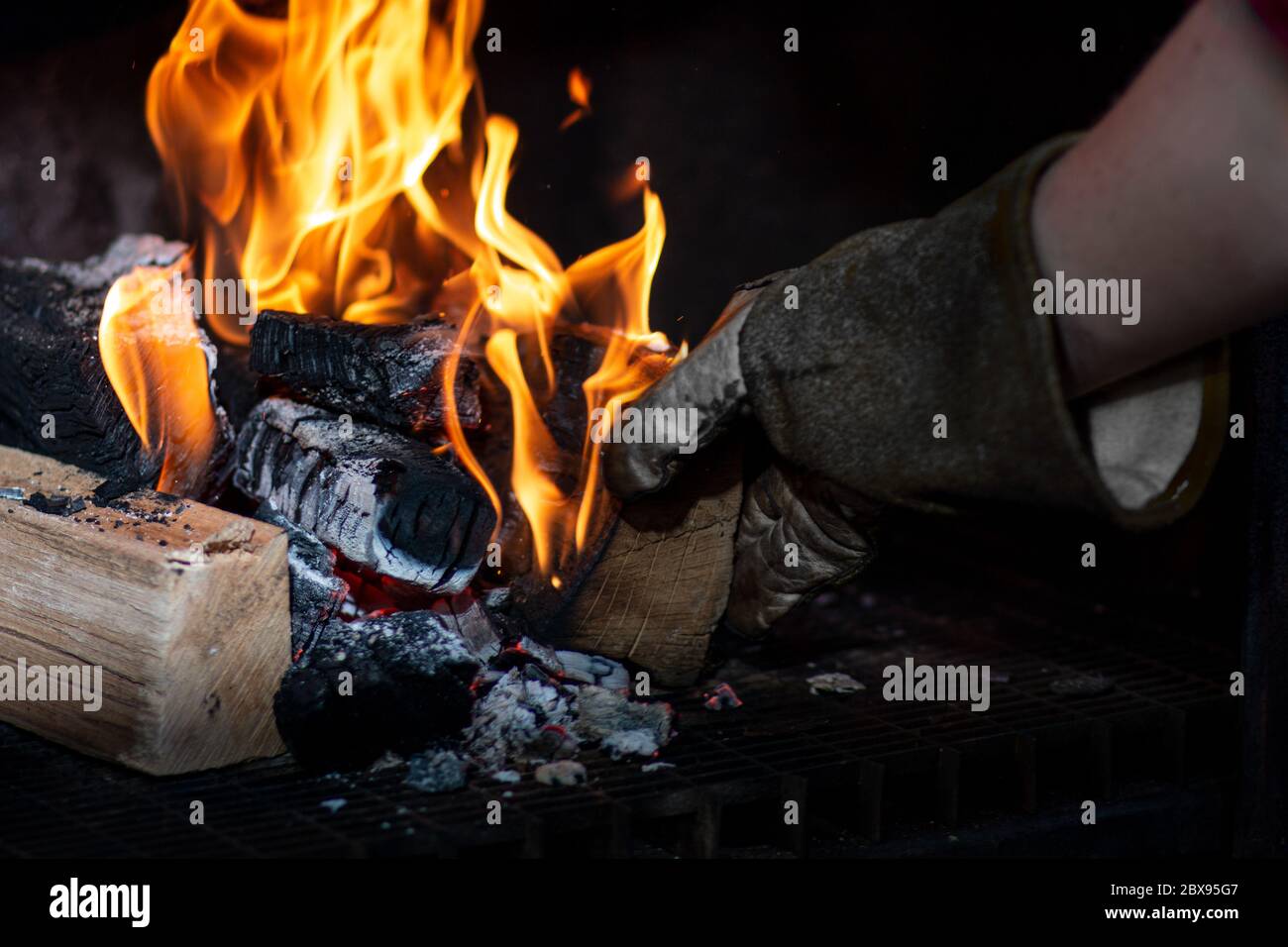 burning stove fire place flames grill barbecue. put more wood on the ...