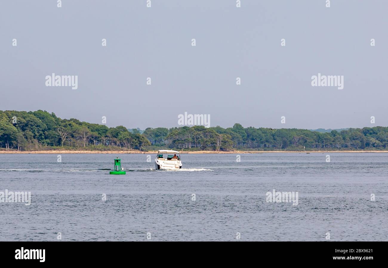 Motor boat cutting around a green channel maker buoy with Shelter ...