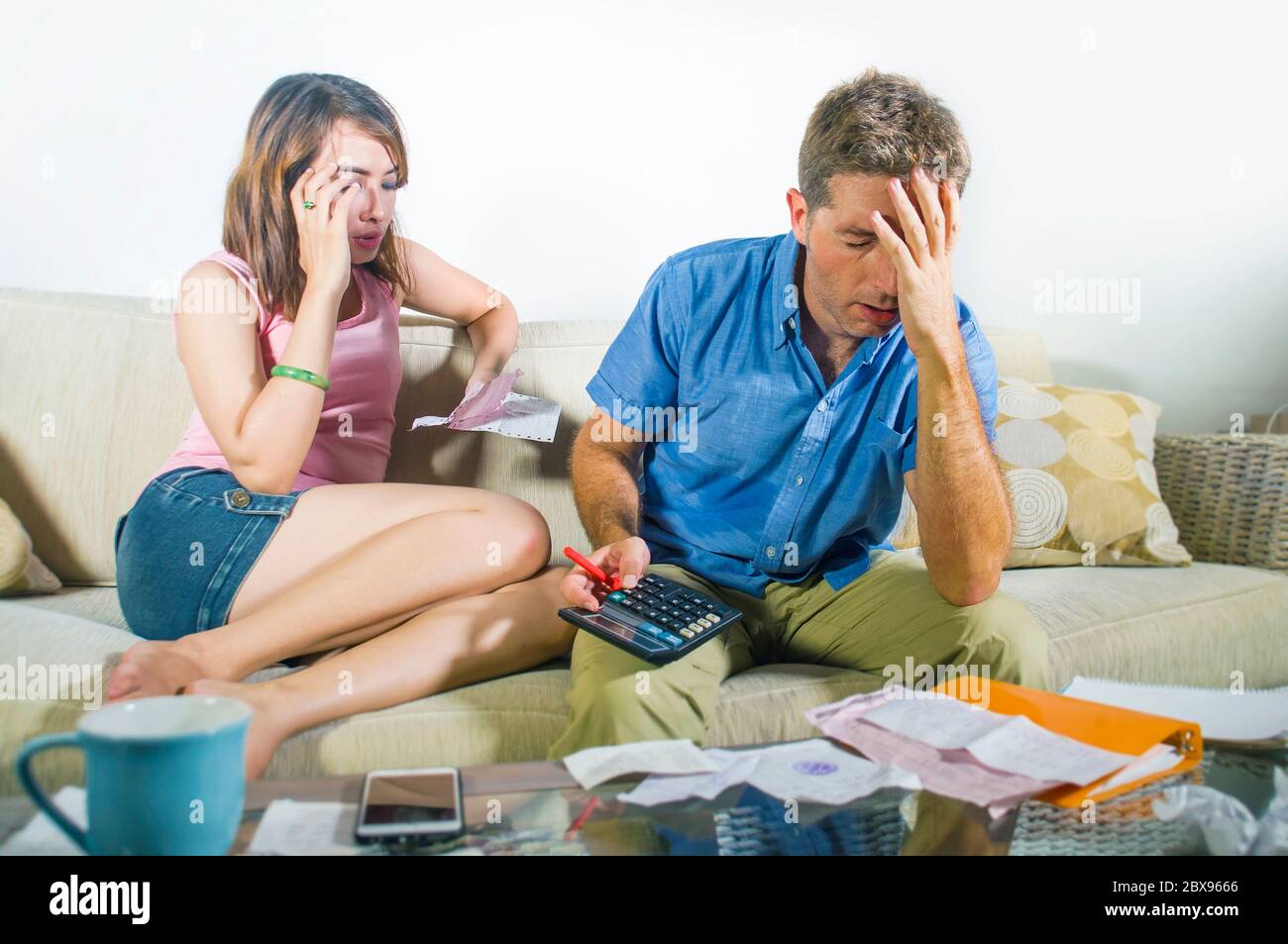 young attractive sad and worried couple accounting together in ...