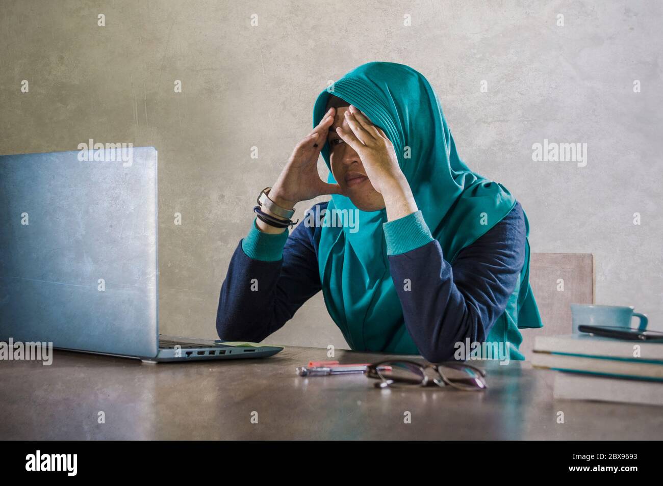 young stressed and overwhelmed Muslim student woman in Islam hijab head ...