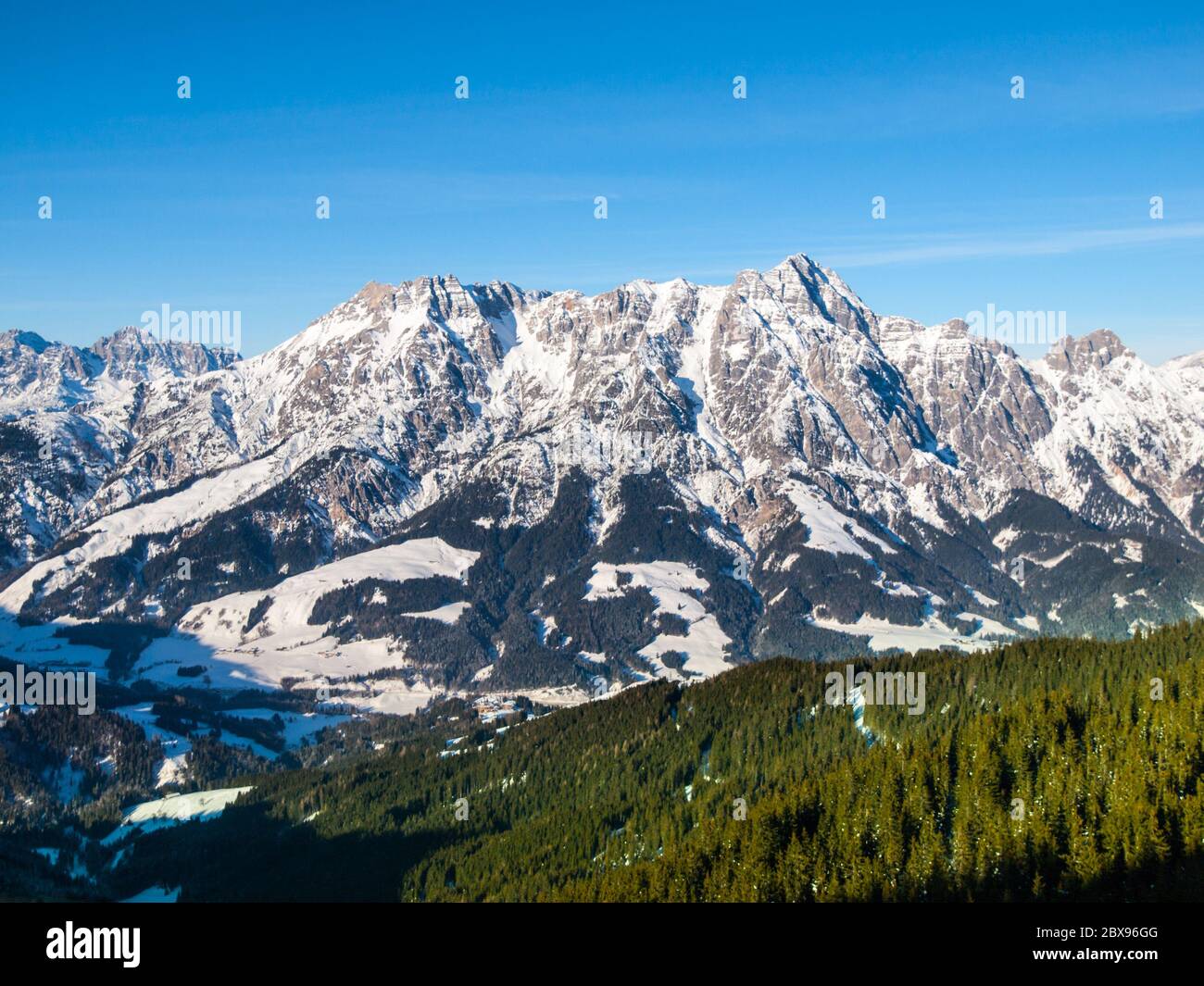 High rocky snowy peak on sunny winter day with blue sky. Alpine ...