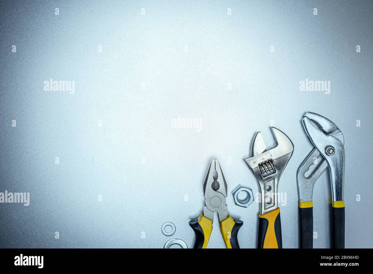 top view of hand tools set of different kinds of pliers on grey metal ...