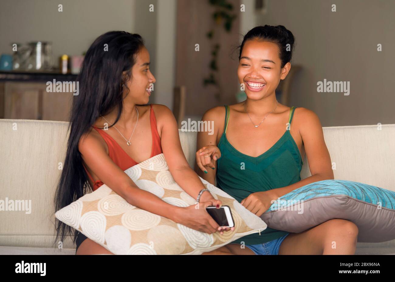 Lifestyle Portrait Of Two Young Happy And Relaxed Asian Girlfriends