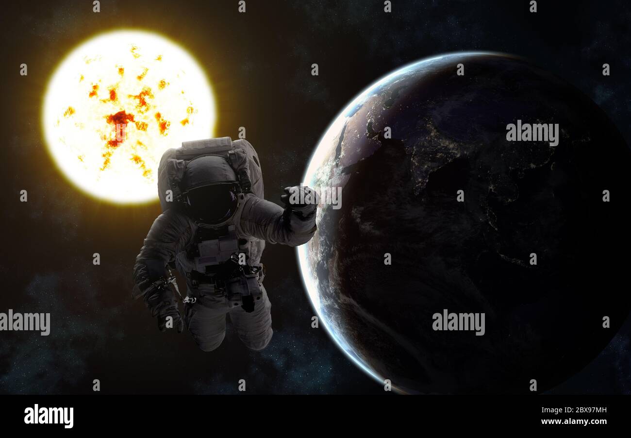 Astronaut. Sun and Earth. Solar system Stock Photo - Alamy