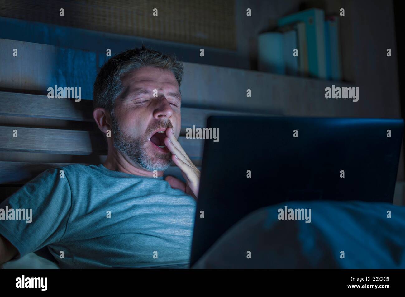 attractive tired and stressed workaholic man working late night ...