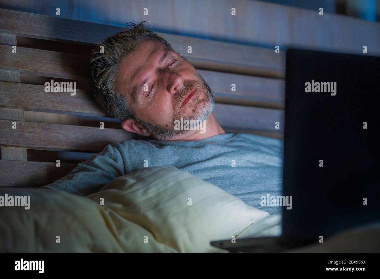 young tired and exhausted internet or work addict man sleeping while ...