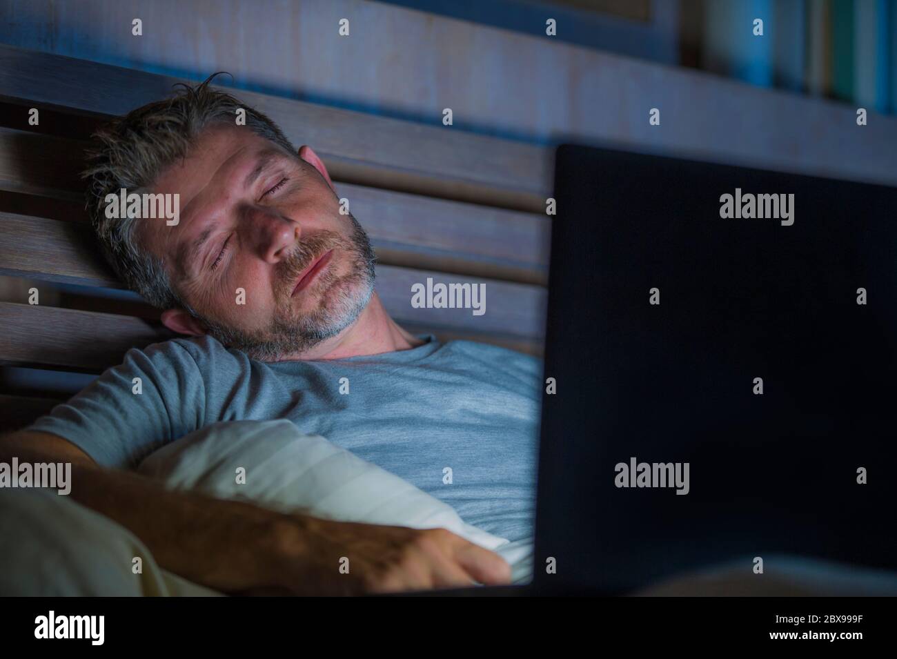 young tired and exhausted internet or work addict man sleeping while ...