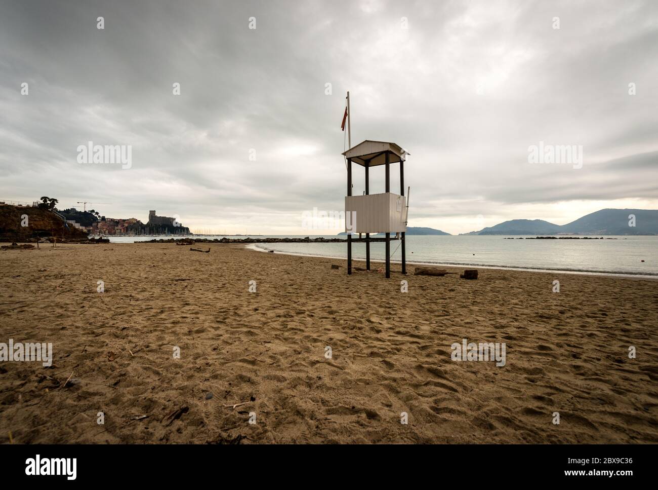 Empty beach in winter with a lifeguard tower and red flag near the ...