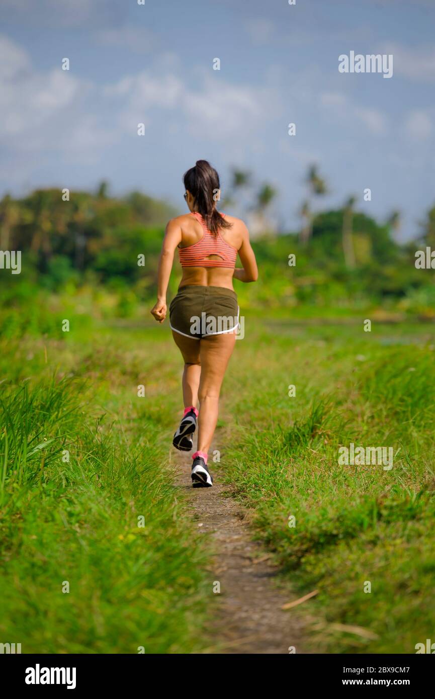 back view of attractive and fit Asian sport woman training running ...