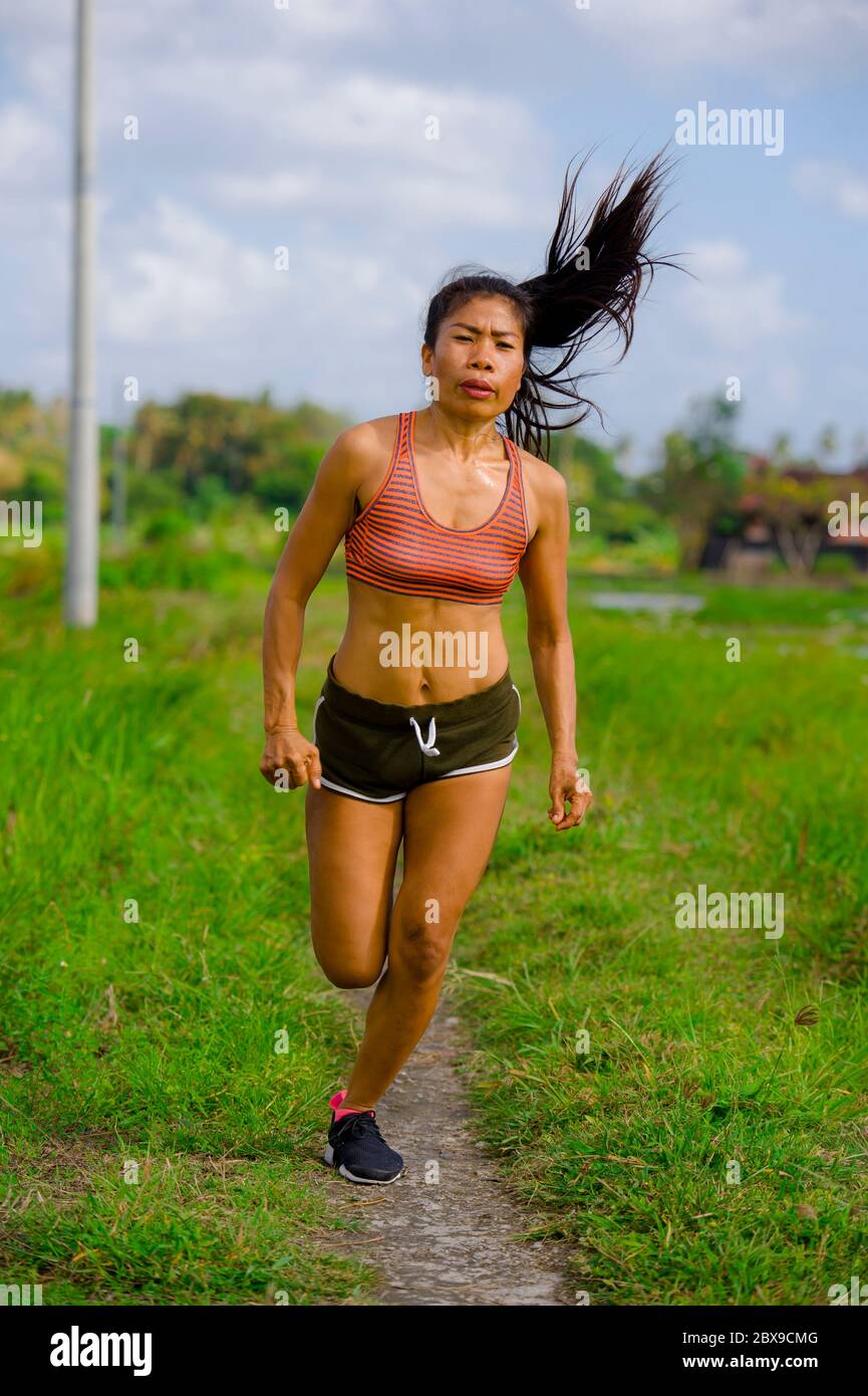 attractive and very fit Asian sport woman training running workout at ...