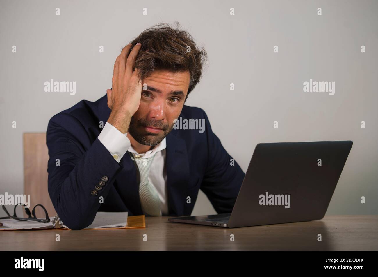 young sad and depressed business man working overwhelmed and frustrated ...