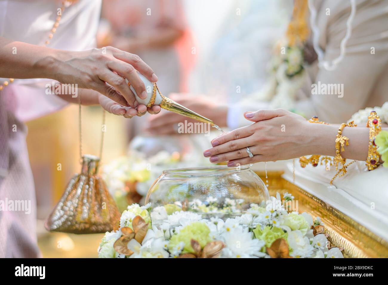 Holy water pouring ceremony over bride and groom hands, Thai ...