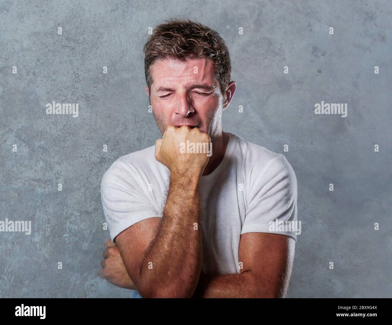 portrait of sad and depressed man biting his fist desperate feeling ...