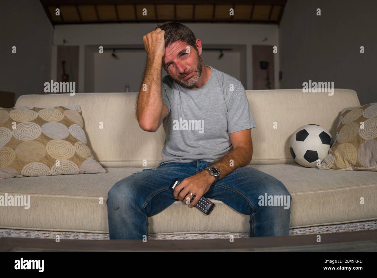 young sad and frustrated soccer fan man watching football game on ...