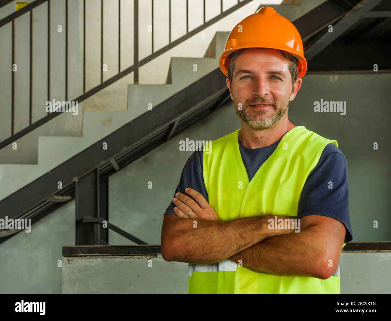 blue collar construction worker. Corporate portrait of young attractive ...