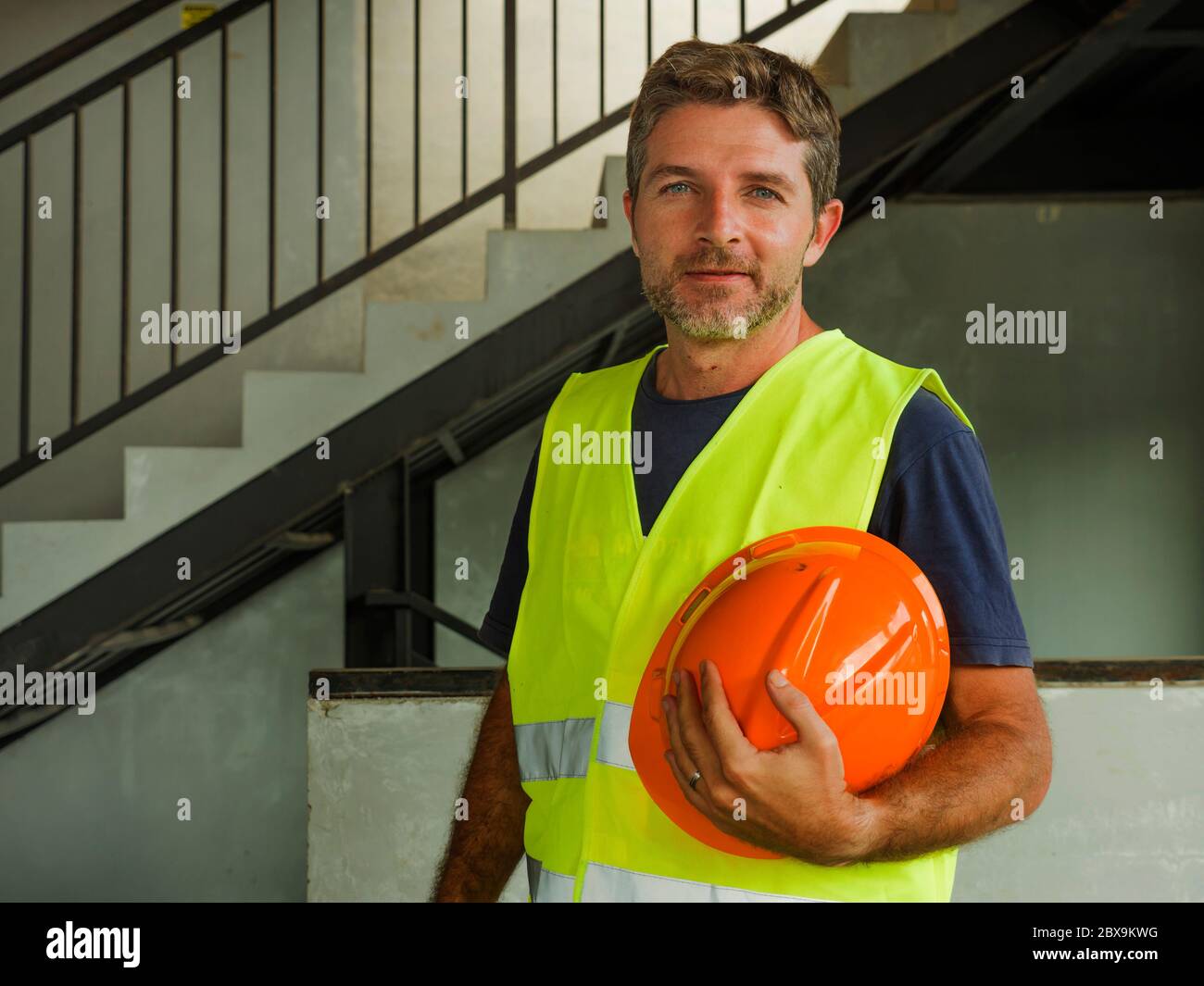 blue collar construction worker. Corporate portrait of young attractive ...