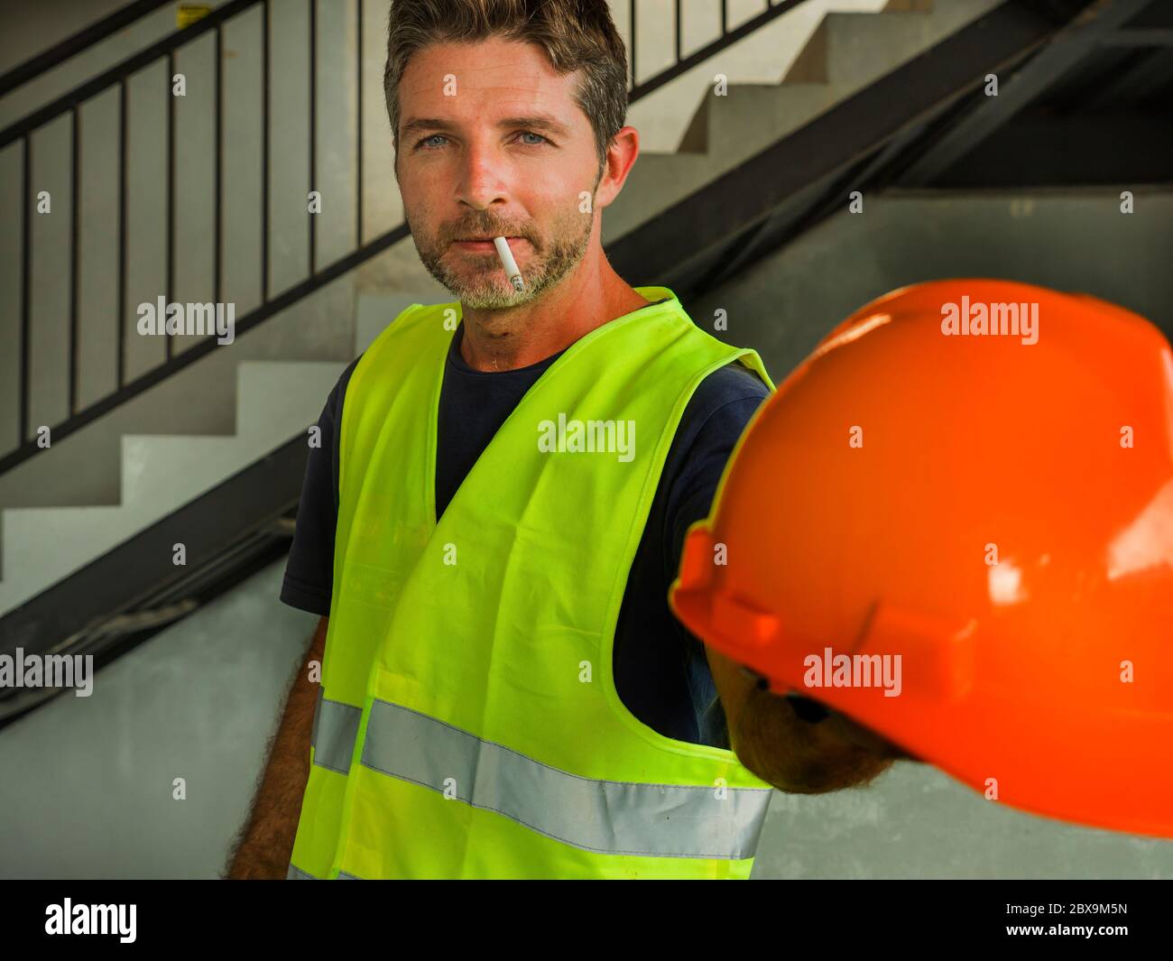blue collar construction worker. Corporate portrait of young attractive ...