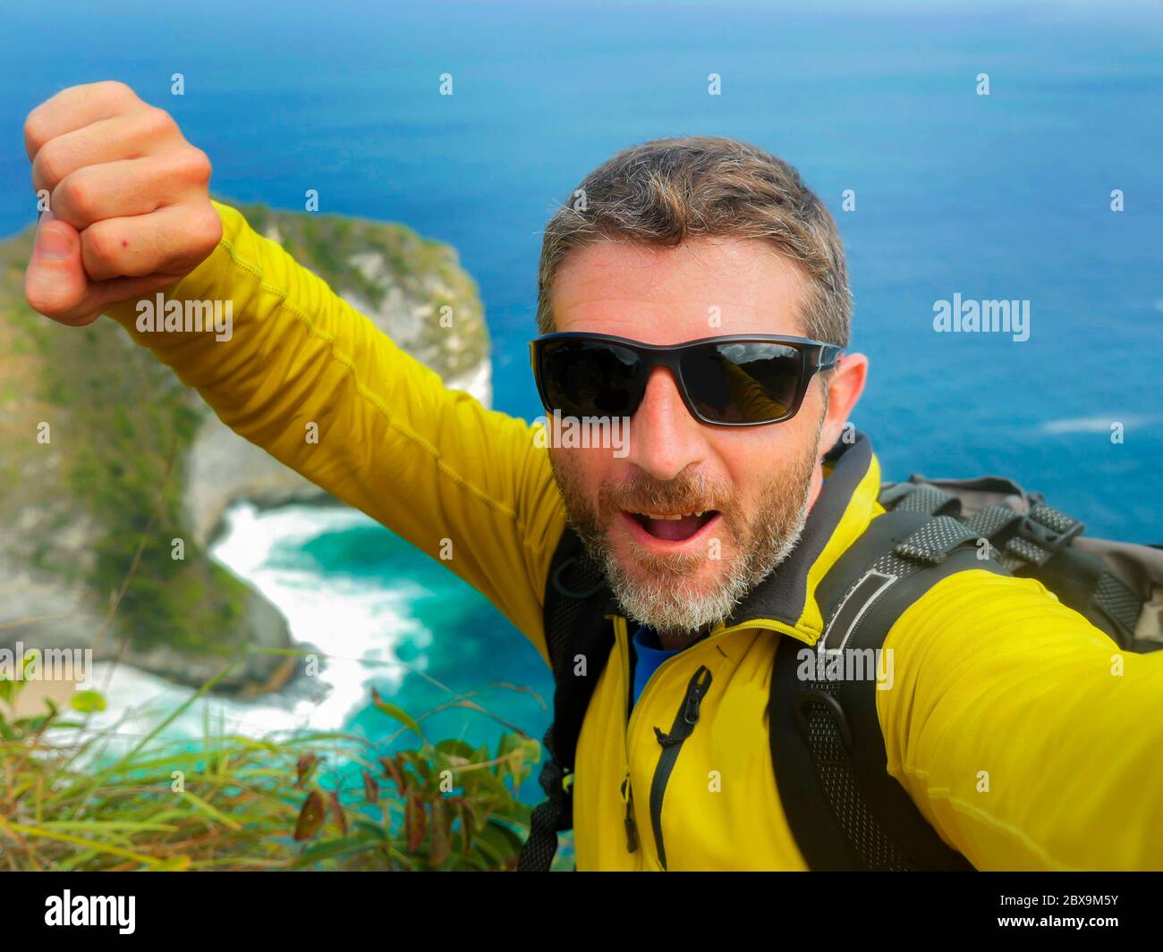 young happy and attractive sporty hiker man with trekking backpack ...