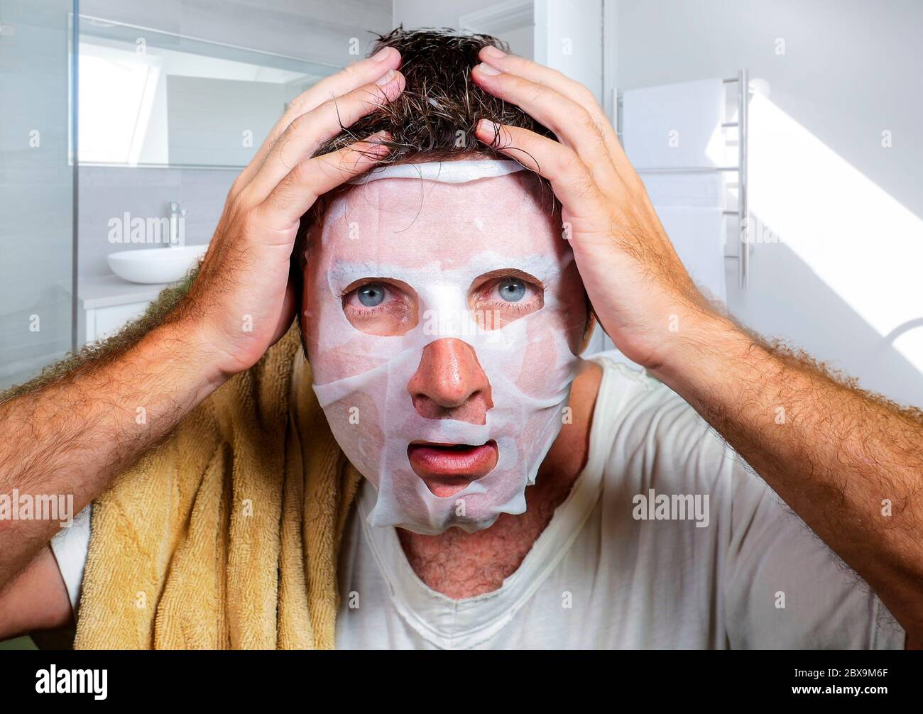 lifestyle bathroom portrait of young scared and surprised man at home ...