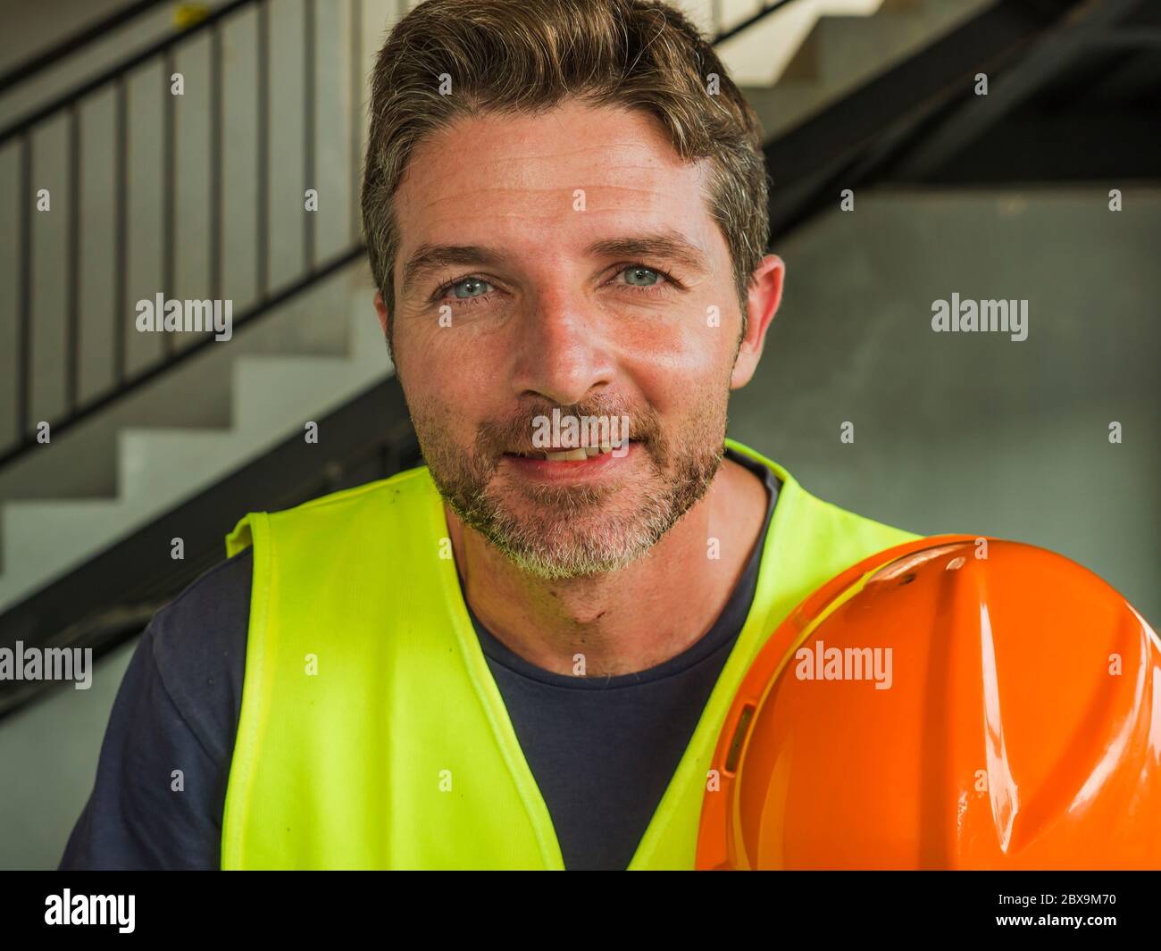 blue collar construction worker. Corporate portrait of young attractive ...