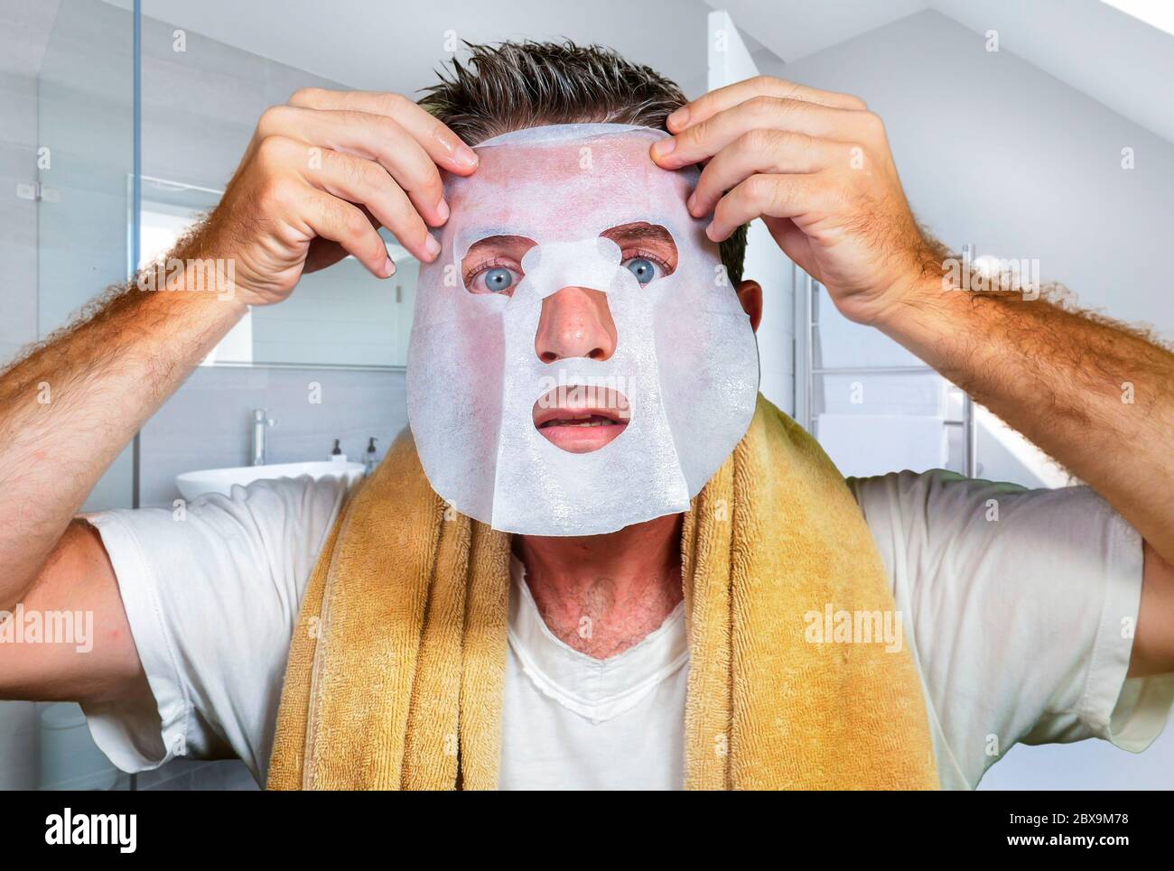 lifestyle bathroom portrait of young scared and surprised man at home ...