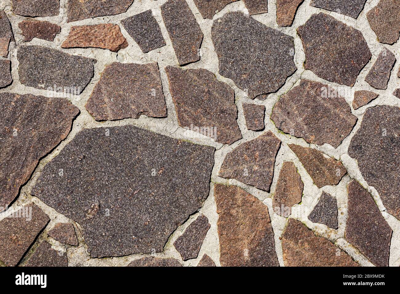 Close-up of an outdoor flooring made with irregular porphyry slabs ...