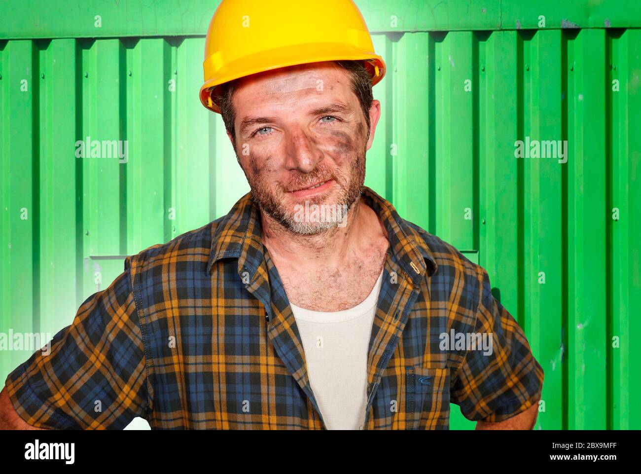 lifestyle portrait of young attractive and confident contractor or construction worker man with ...