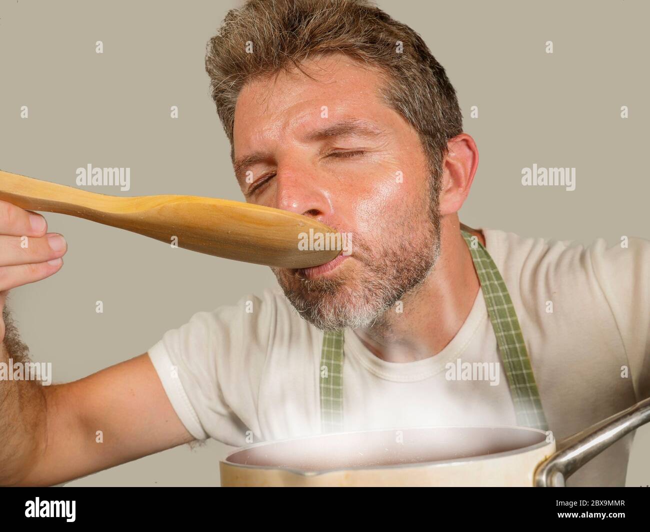 young happy and attractive home cook man in apron cheerful and charming ...