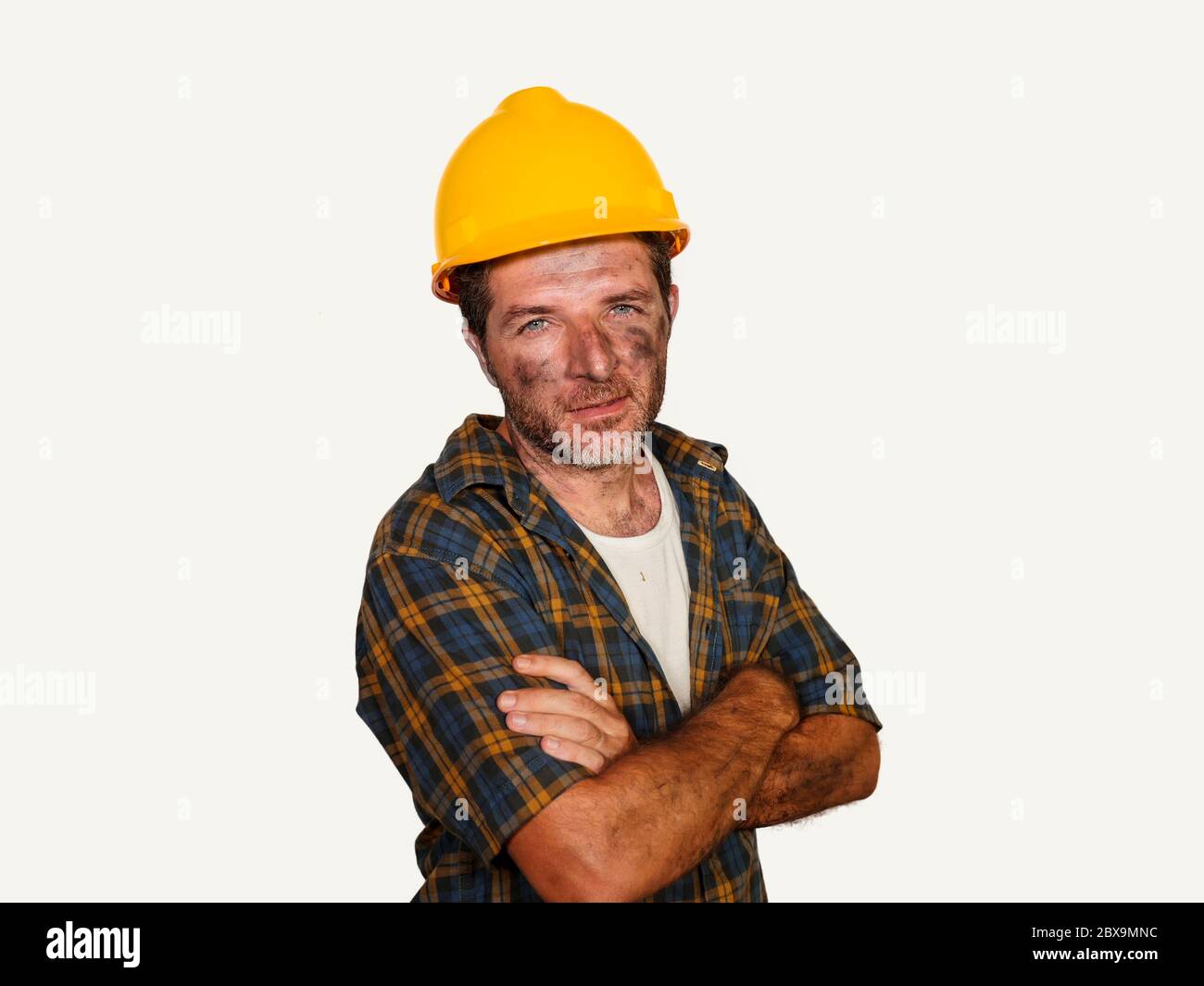 corporate portrait of construction worker. Attractive and happy builder man in safety helmet ...