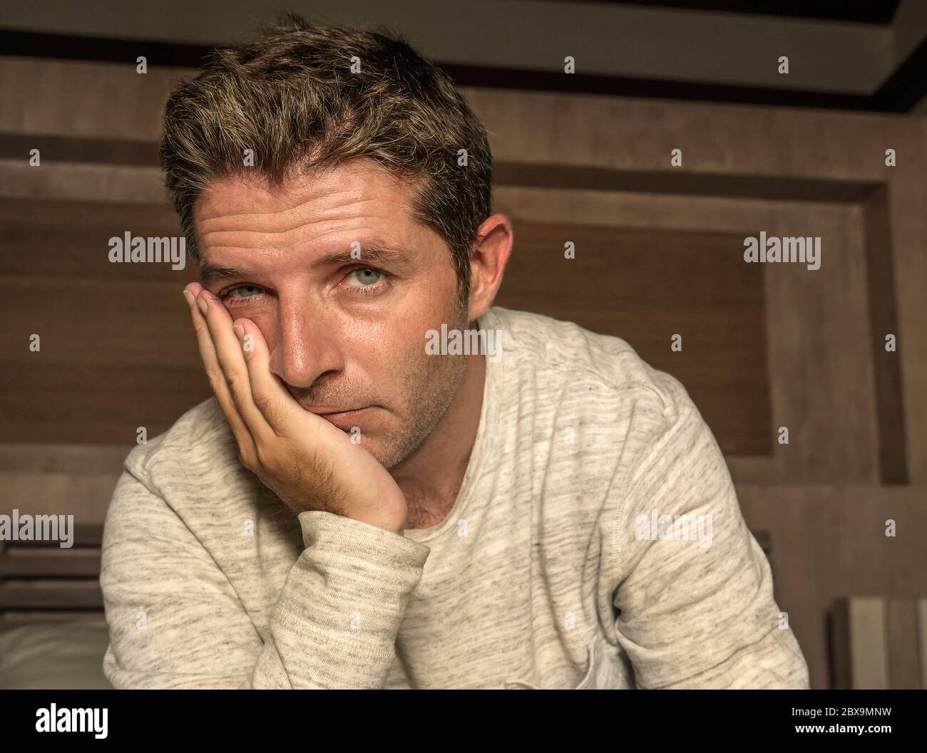 dramatic home portrait of 30s to 40s attractive depressed and desperate ...