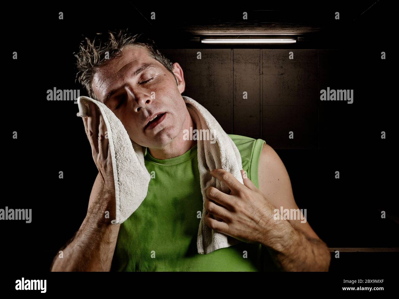 dark edgy portrait of young sweaty tired and exhausted sport man with ...