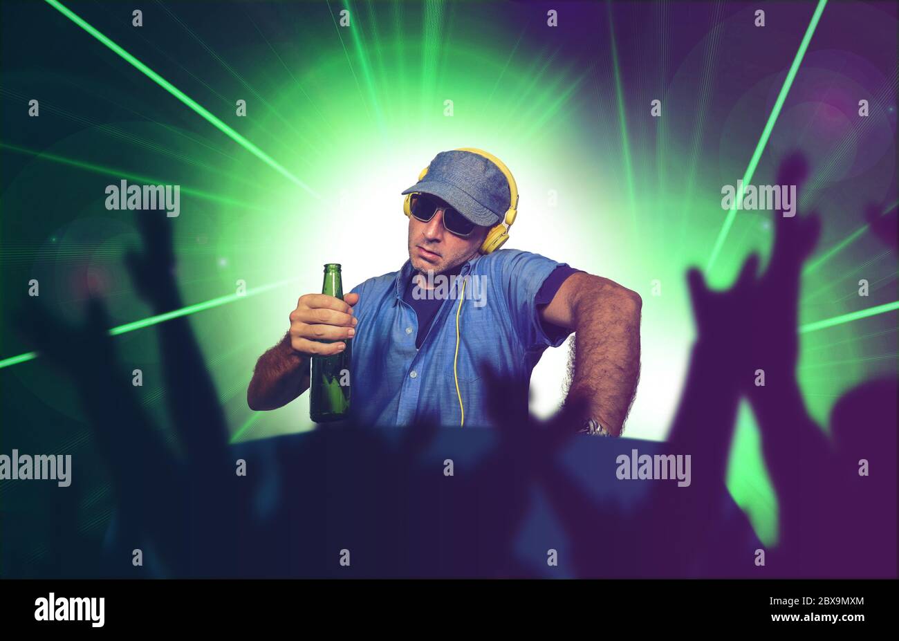 young happy and cool DJ playing music at party event in night club ...