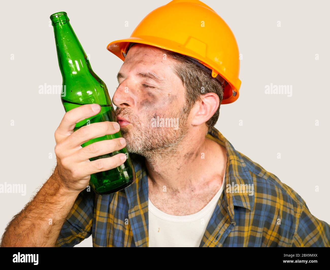 funny portrait of thirsty and tired constructor worker or builder man in safety helmet feeling ...