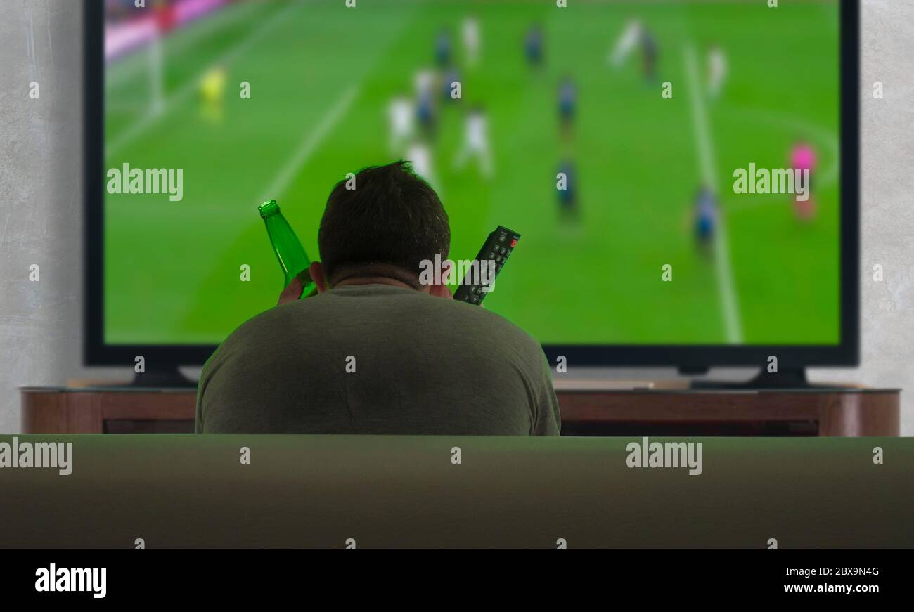 view from behind of young soccer fan man watching European football ...