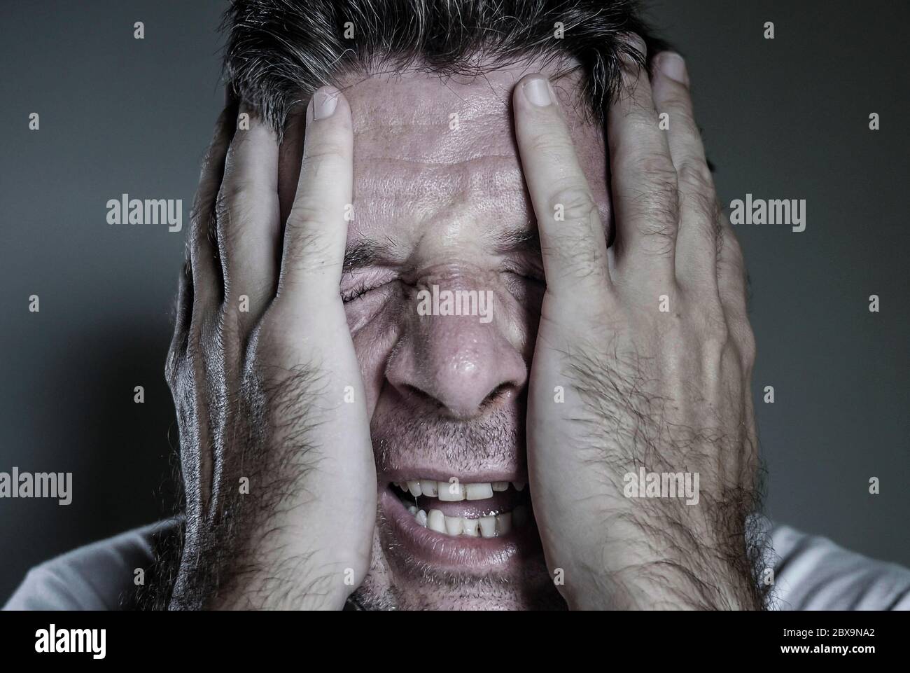head and shoulders dramatic portrait of young man crying in pain ...