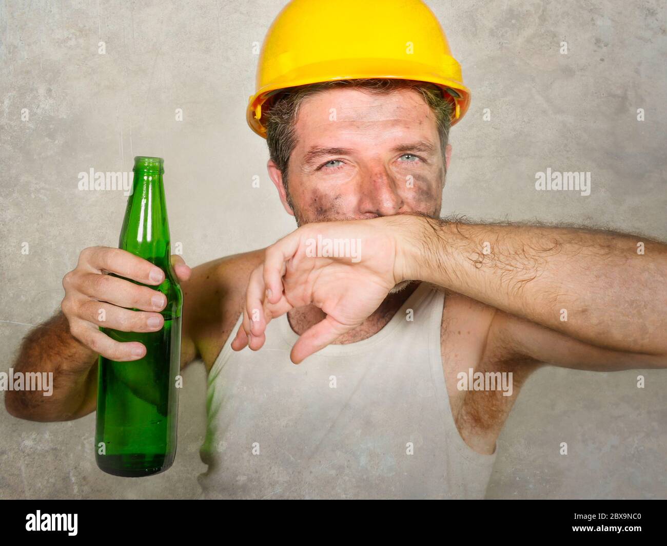 thirsty and tired constructor worker or builder man in safety helmet feeling exhausted drinking ...