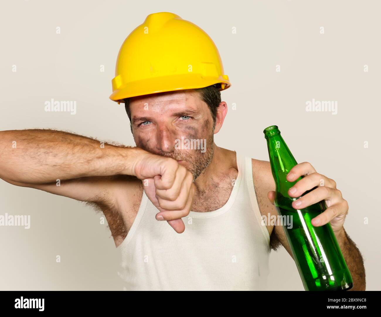 thirsty and tired constructor worker or builder man in safety helmet feeling exhausted drinking ...