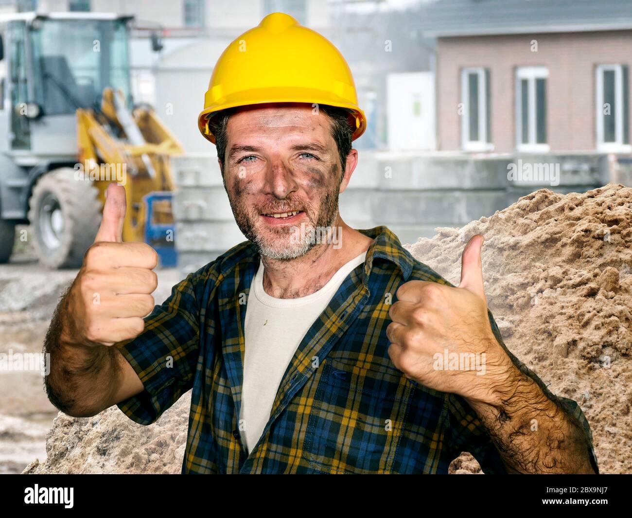 lifestyle portrait of young attractive and confident contractor or construction worker man with ...