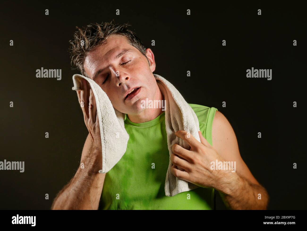 young sweaty tired and exhausted sport man drying sweat after hard ...