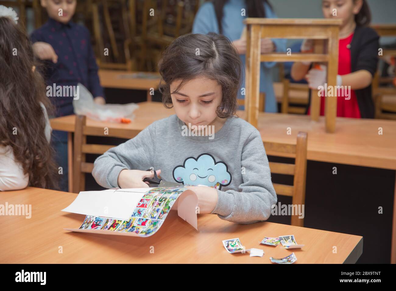 Portrait of a little girl cutting a paper . Little preschooler girl ...