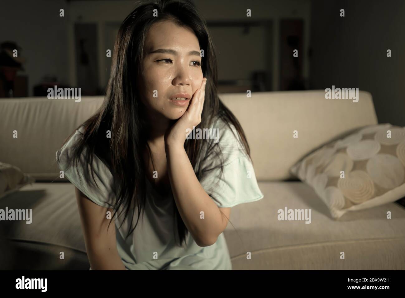 dramatic lifestyle portrait of young beautiful sad and depressed Asian ...
